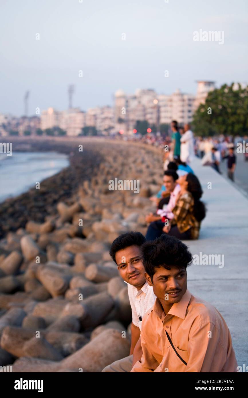 Indians enjoy the setting sun over the Arabian Sea along the waterfront ...