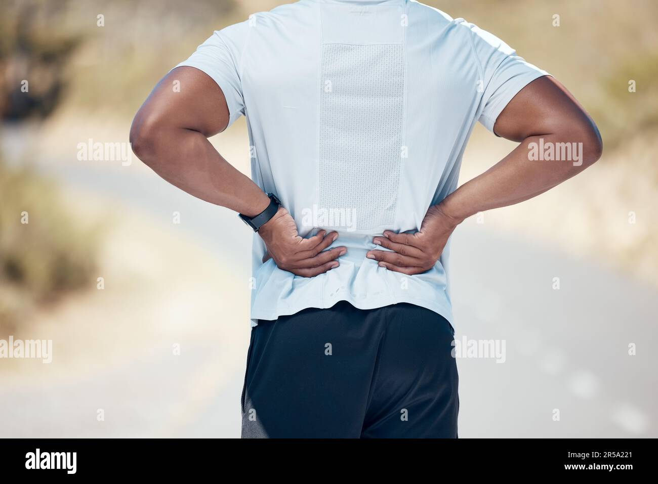 Back pain, fitness and man on the road, training and exercise with ...