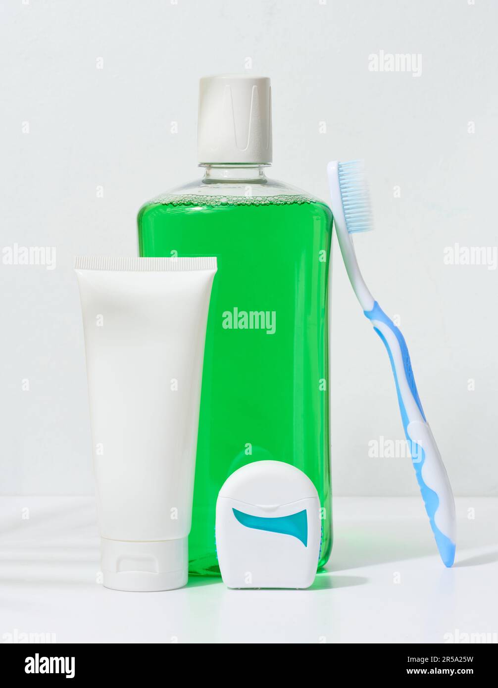 Refreshing mouthwash in a transparent plastic bottle and dental floss ...