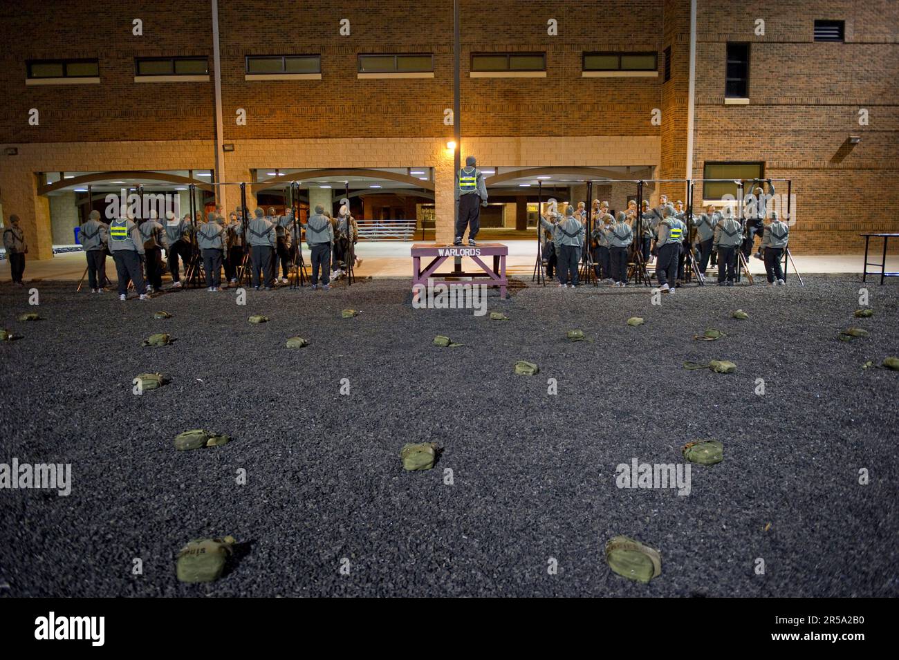 Before dawn, soldiers in basic training do chin-ups from a high bar ...