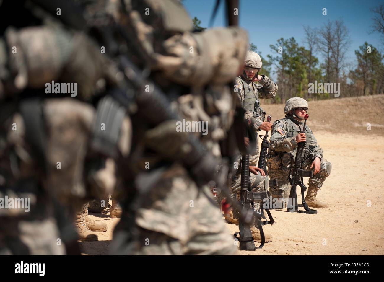 Soldiers in basic training listen to the drill sergeant demonstrate ...