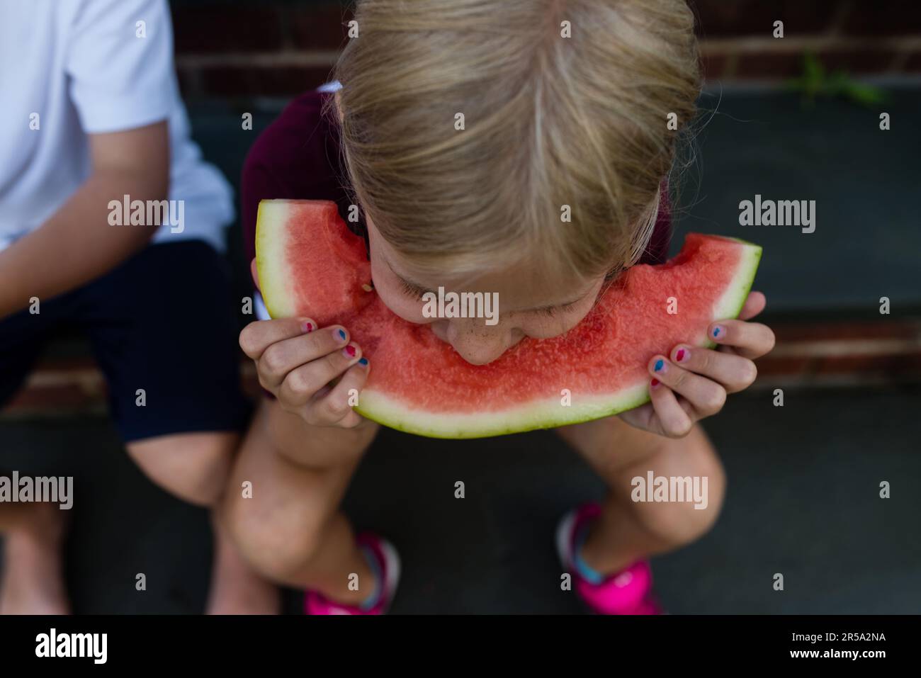 above view of girl biting into watermelon Stock Photo - Alamy
