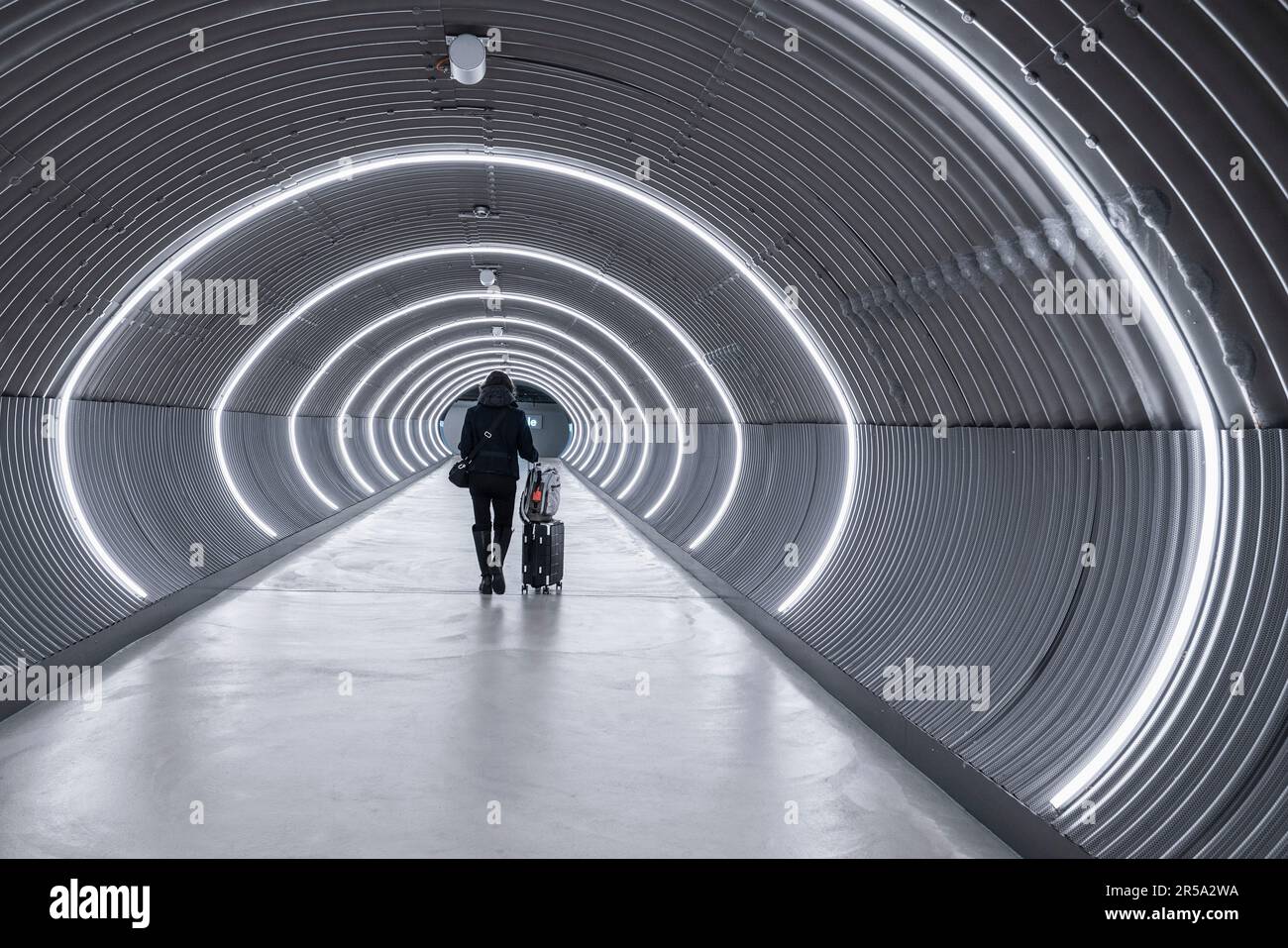 business traveller walking through lit up tunnel at Zurich airport Stock Photo - Alamy
