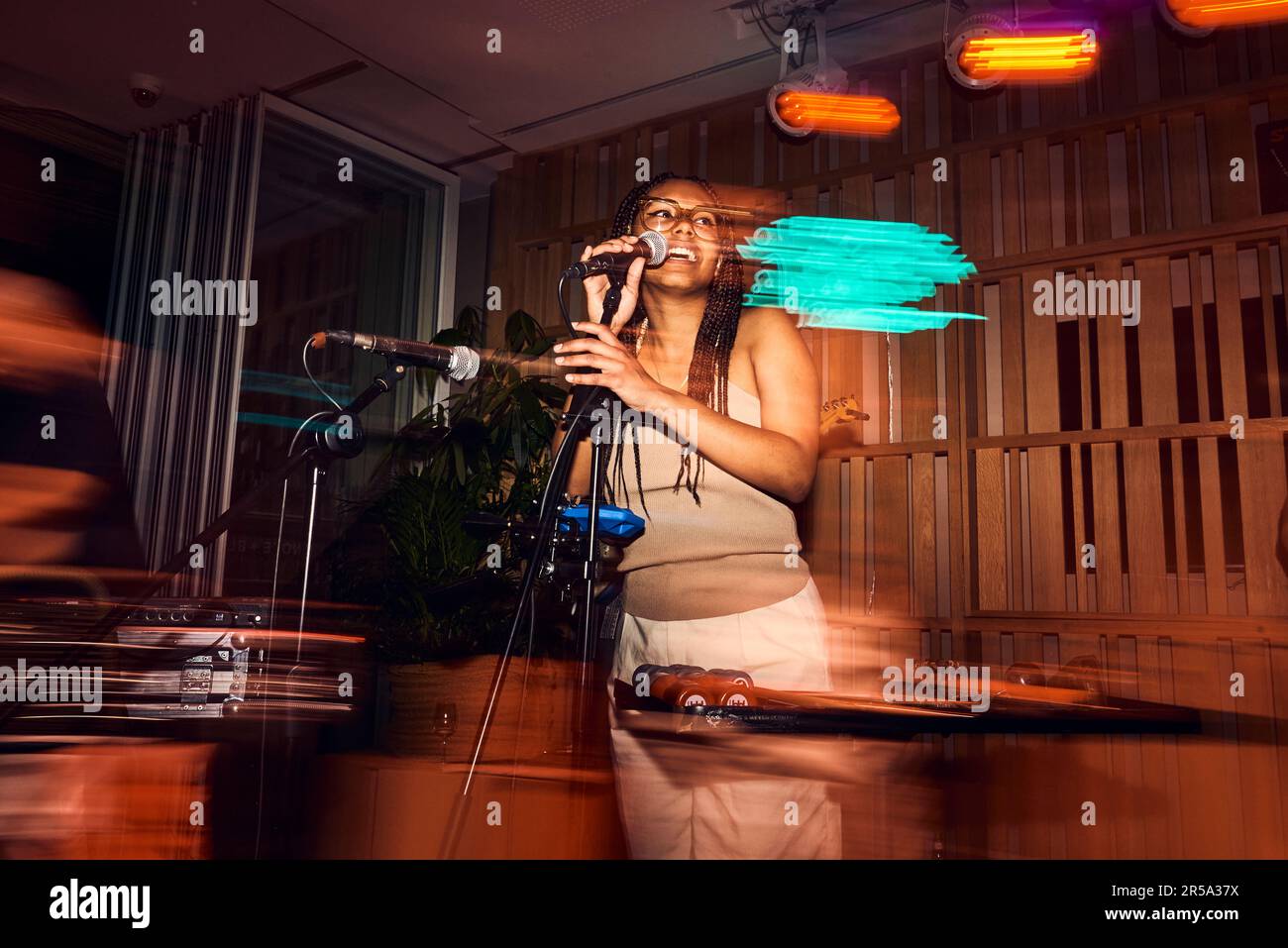 Beautiful black girl talking into microphone during live jazz show ...