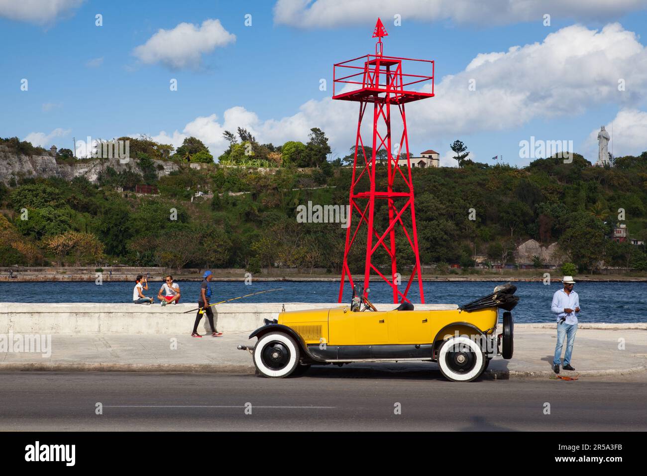 A taxi driver waits for tourists in his yellow cab on the Maleco Stock ...
