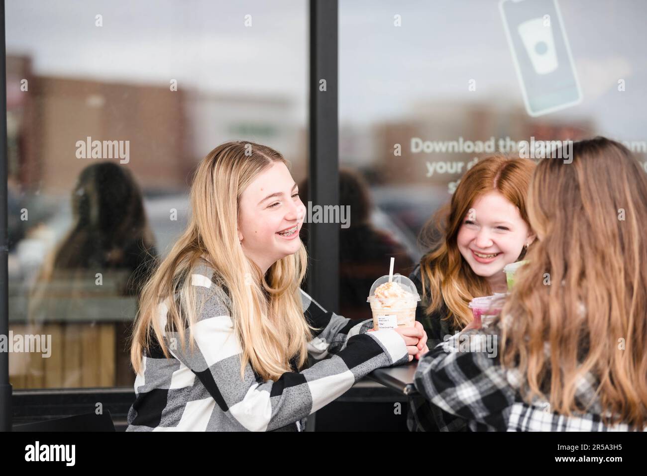 Three happy teen girls having drinks outside a coffee shop Stock Photo ...