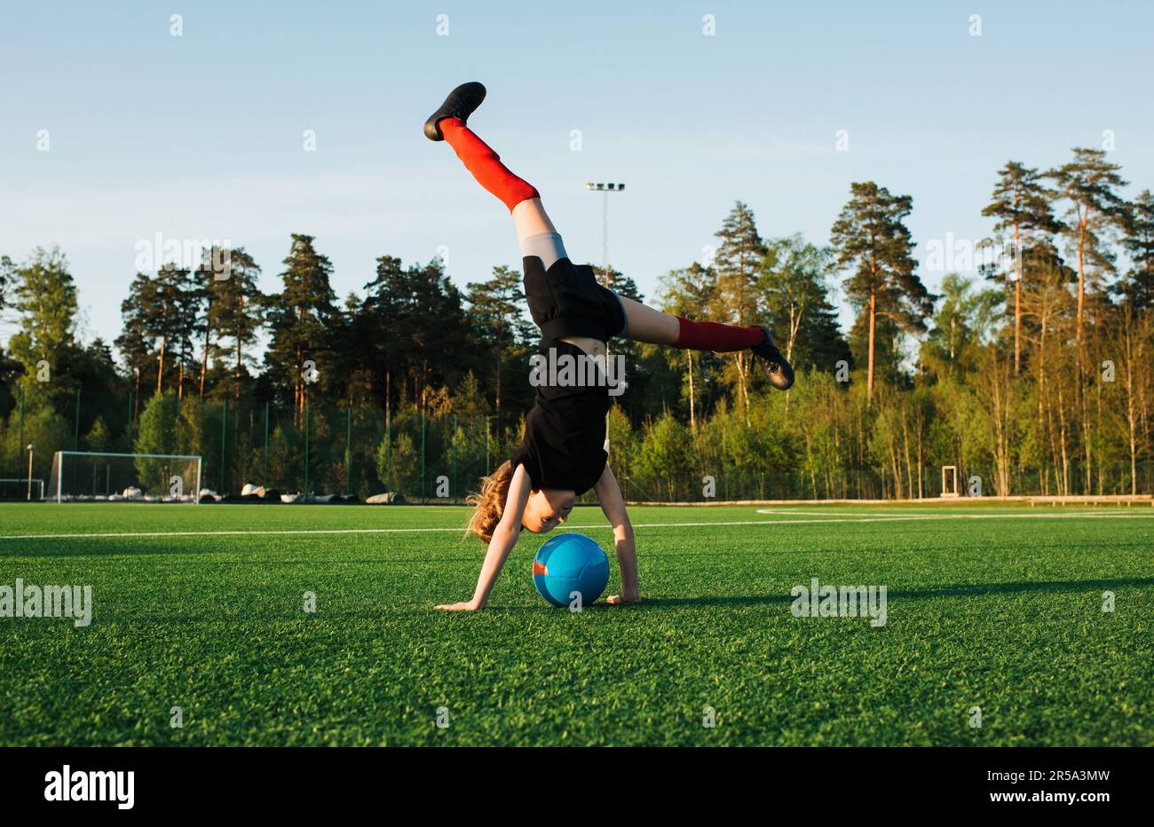 girl doing a handstand over a football in a football pitch Stock Photo ...