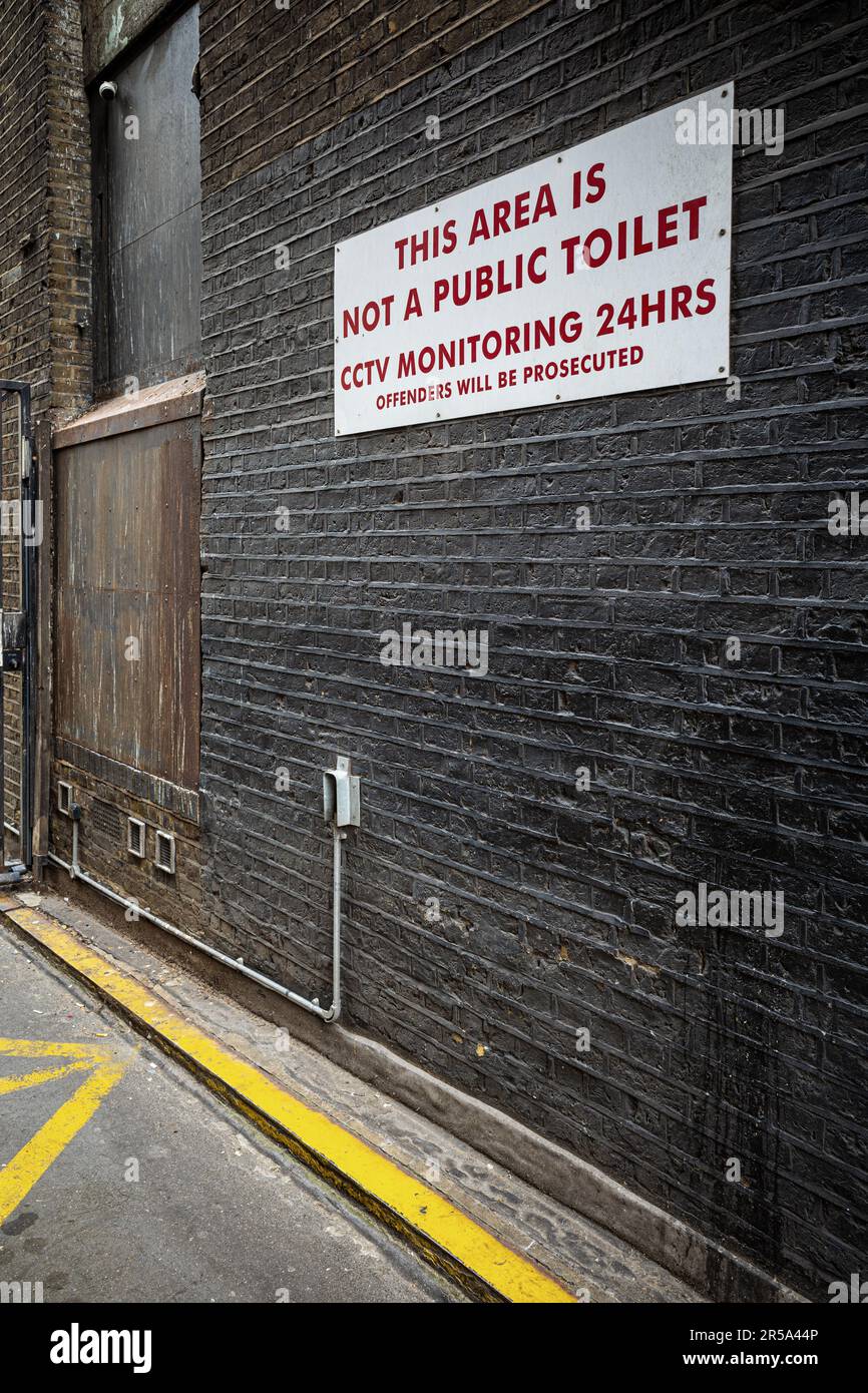 This is not a public toilet warning sign in a London alley. Sign in an ...