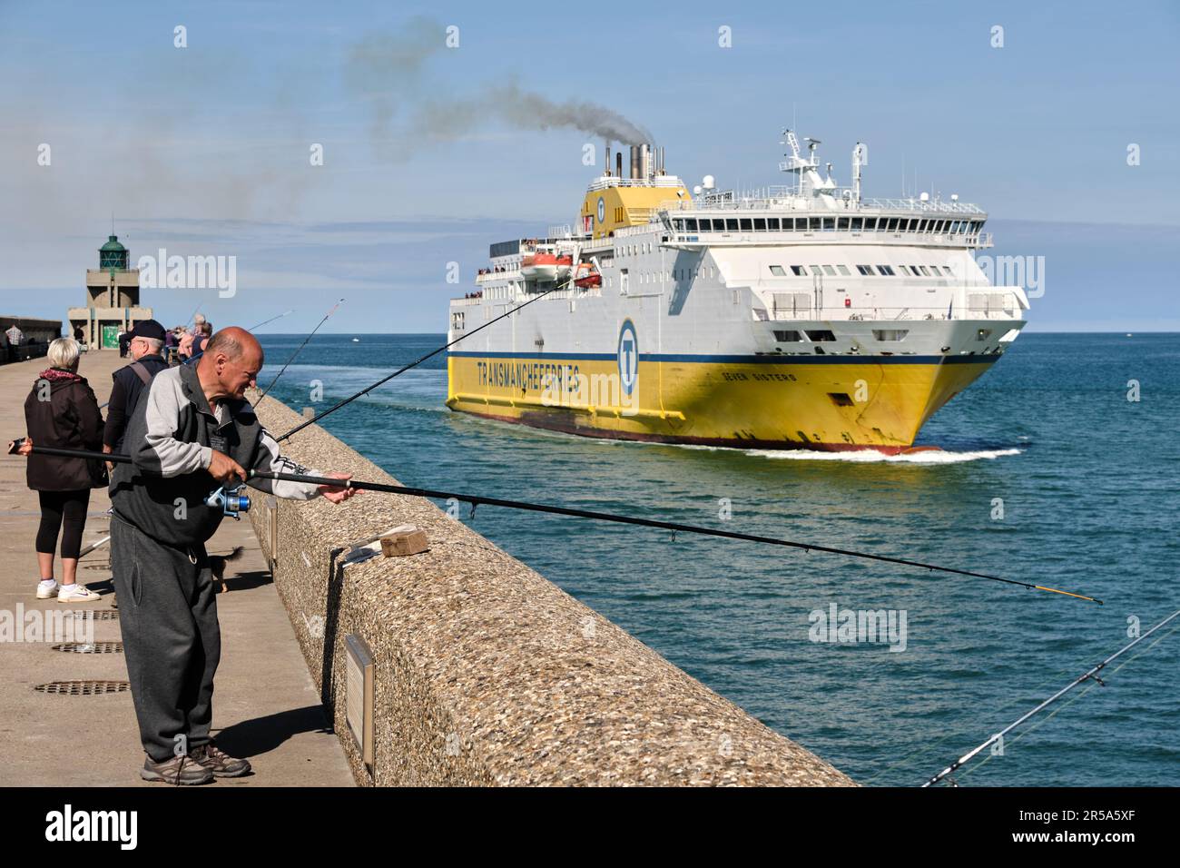 Dieppe, Normandy, France - September 21 2022: Man fishing as the DFDS passenger ferry from ...