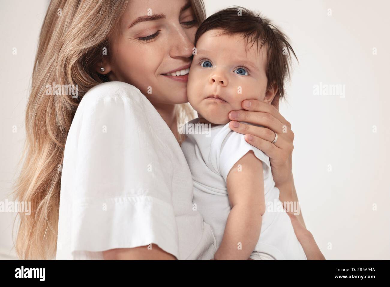 Mother hugging her cute little baby on white background, closeup Stock ...