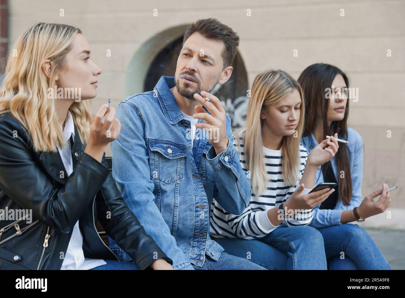People smoking cigarettes at public place outdoors Stock Photo - Alamy