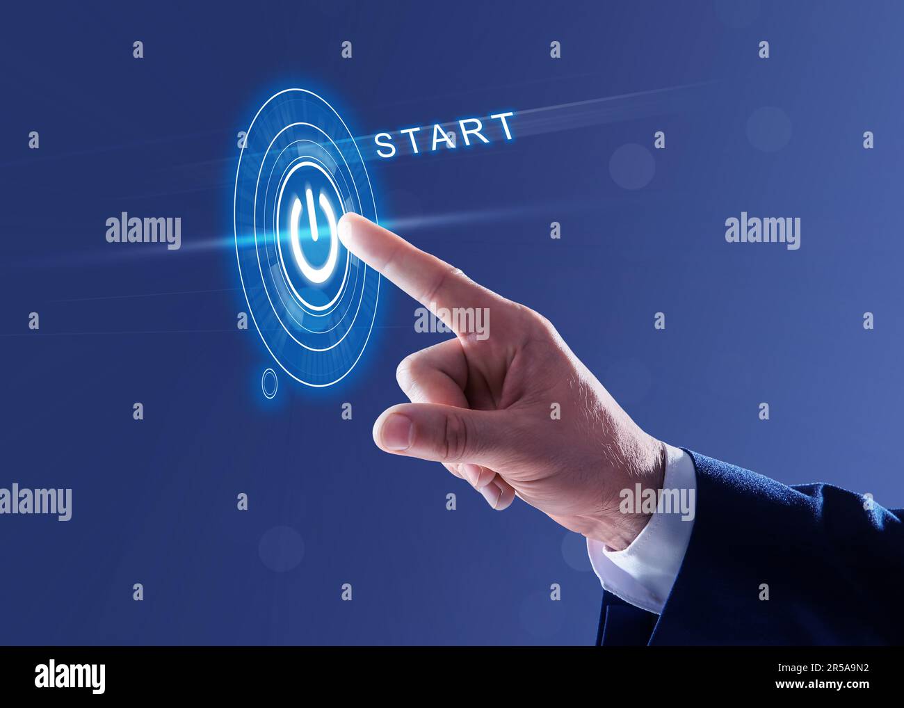 Man pressing start button on virtual screen against blue background ...
