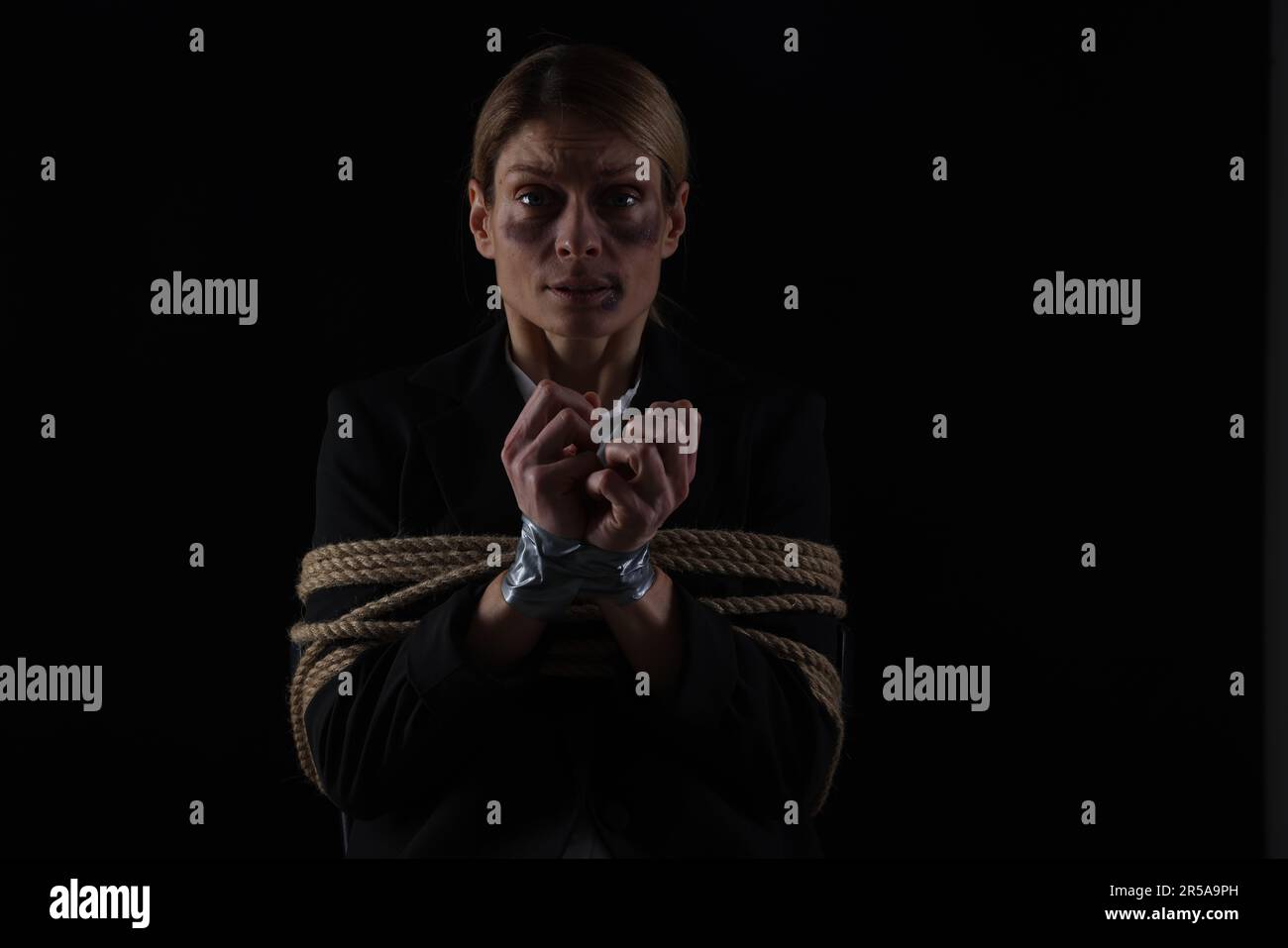 Scared woman tied up and taken hostage on dark background Stock Photo ...