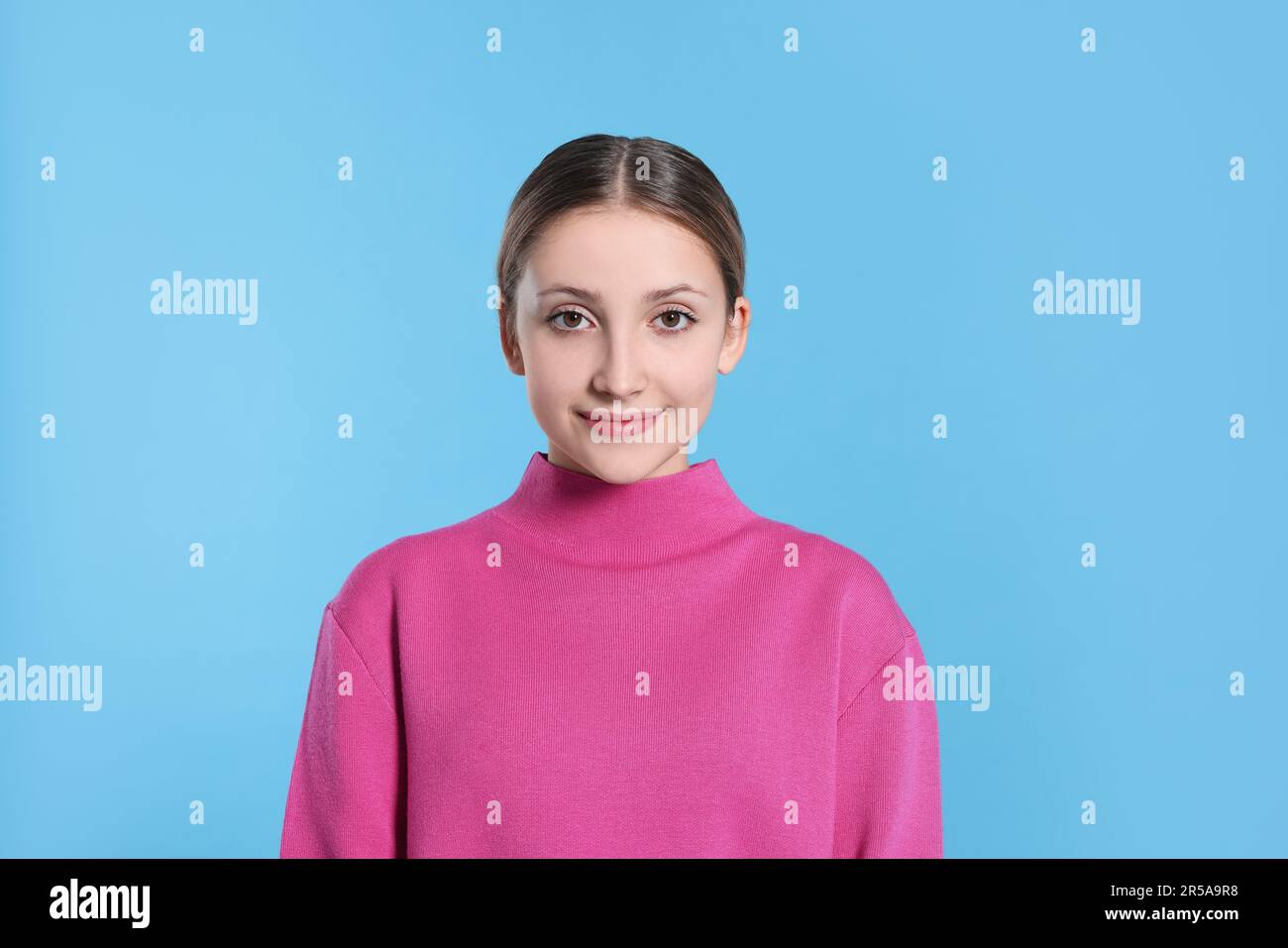 Portrait of beautiful teenage girl on light blue background Stock Photo ...