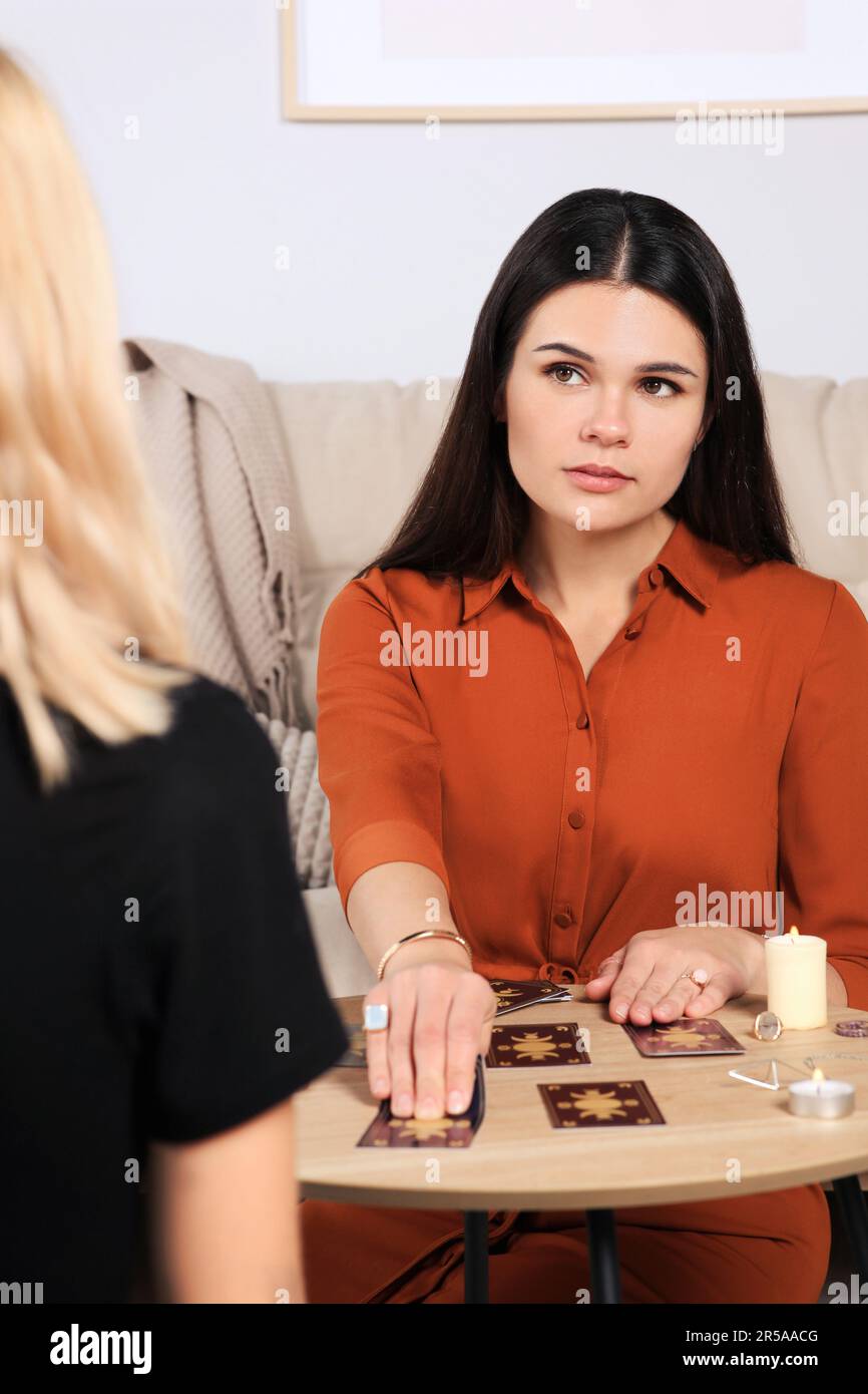 Soothsayer predicting future with tarot cards at table in room Stock ...