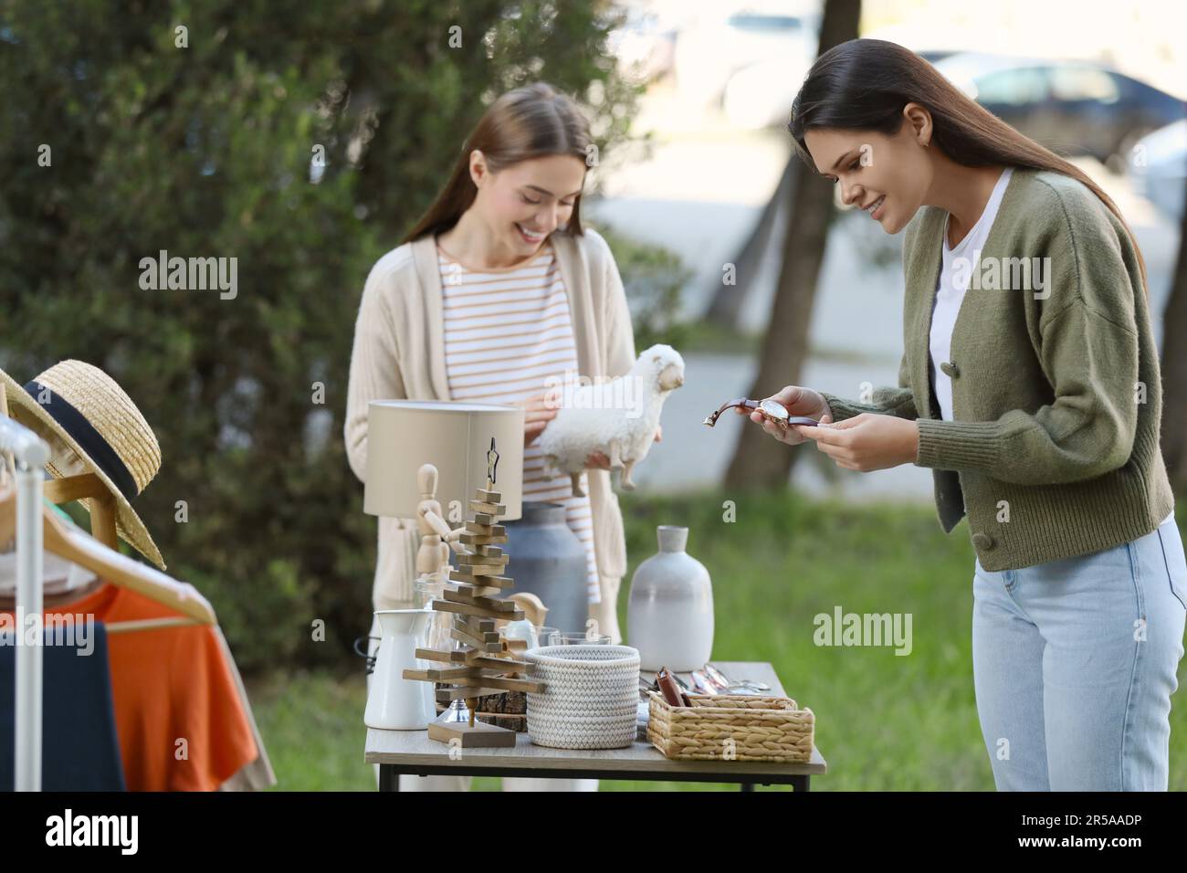 Women shopping at table in yard. Garage sale Stock Photo - Alamy