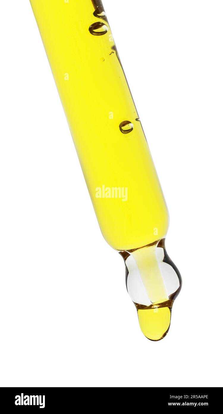 Dripping yellow facial serum from pipette on white background, closeup ...