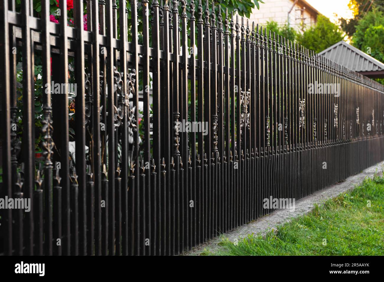 Beautiful black iron fence near pathway outdoors Stock Photo - Alamy