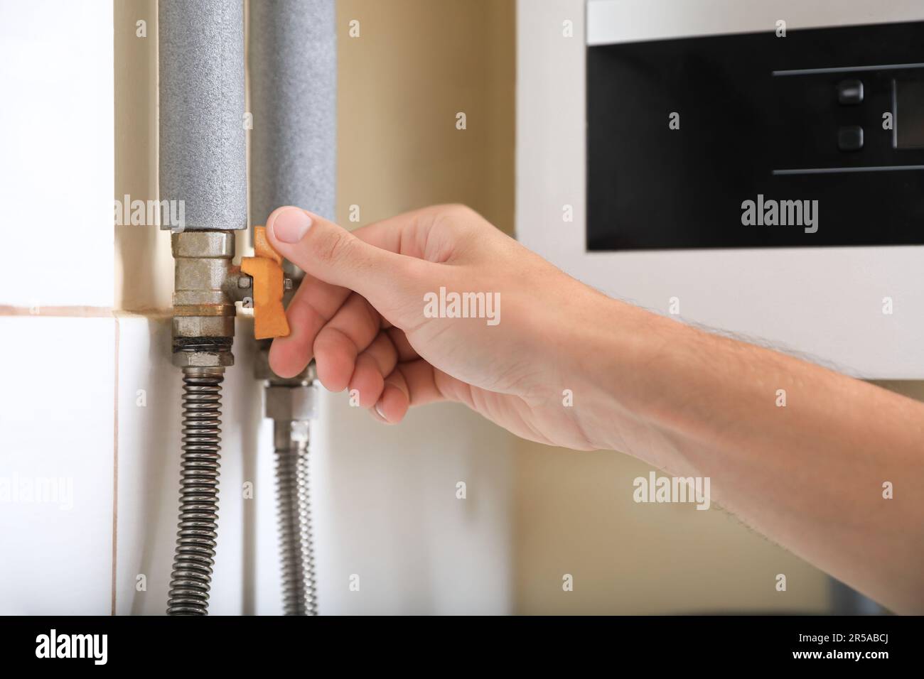 Man turning on valve of gas boiler indoors, closeup Stock Photo - Alamy