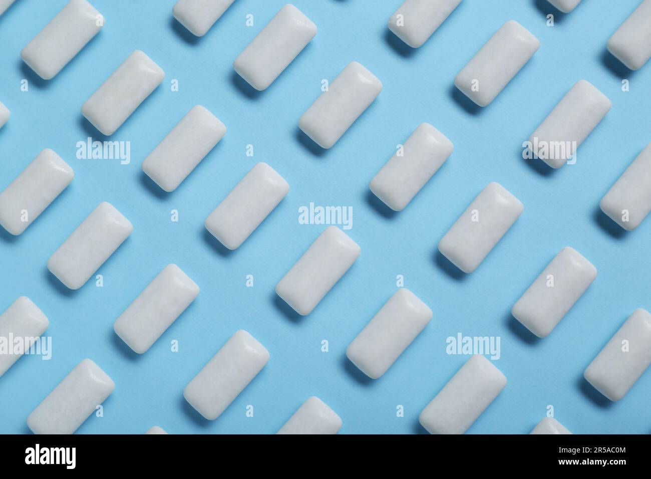 Tasty white chewing gums on light blue background, flat lay Stock Photo ...