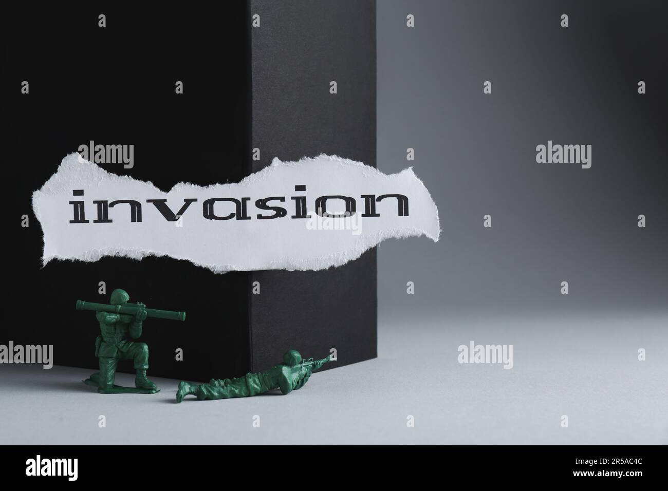 Paper with word Invasion and toy soldiers on light grey background ...