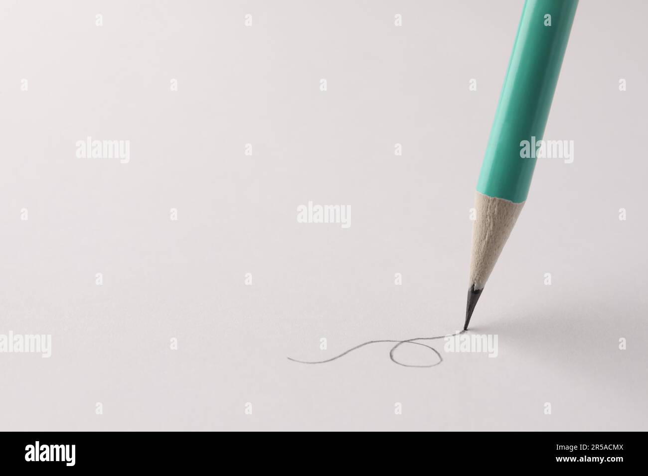 Drawing with sharp graphite pencil on white sheet of paper, closeup ...