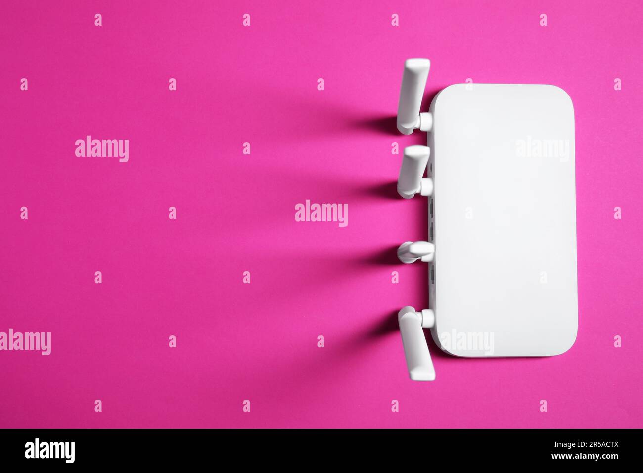 New white Wi-Fi router on pink background, top view. Space for text ...
