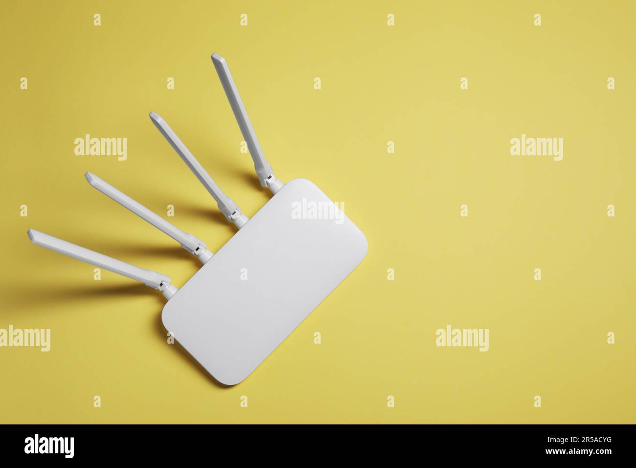 New white Wi-Fi router on yellow background, top view. Space for text ...