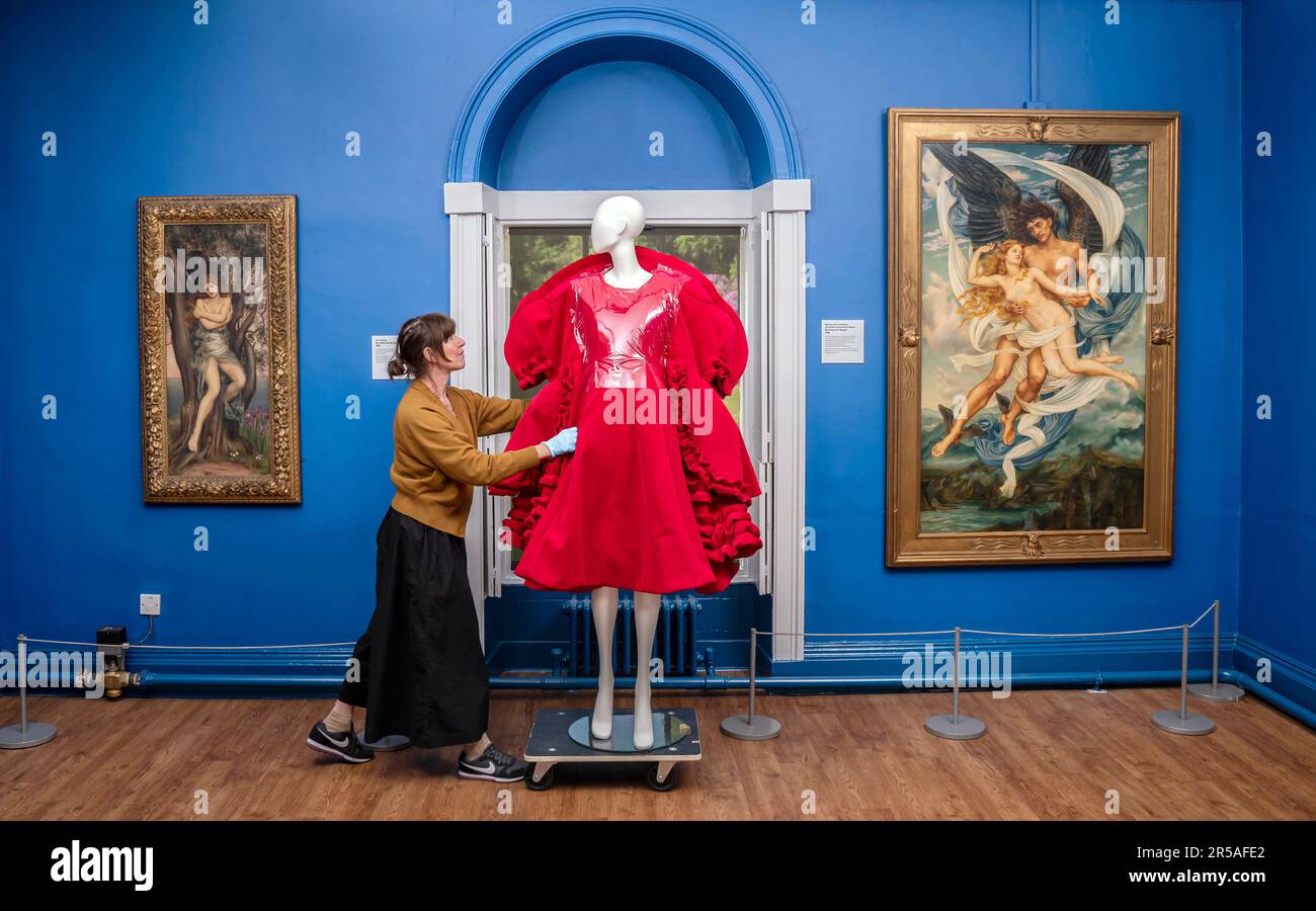 Exhibitions Officer Alison Cooper, moves a red Cotton and Velvet Dress ...