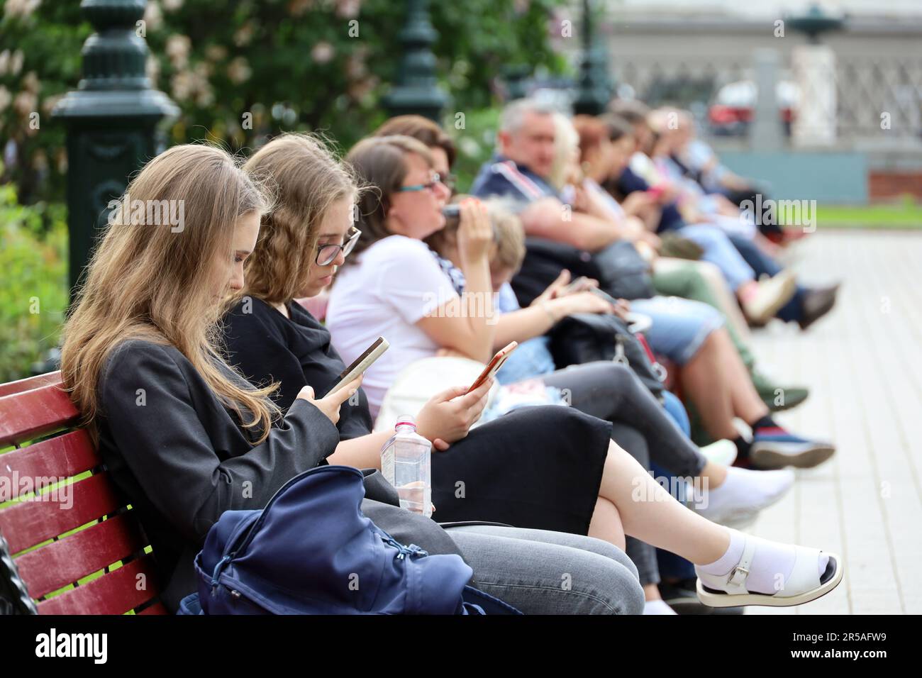 People sitting on park benches hi-res stock photography and images - Alamy
