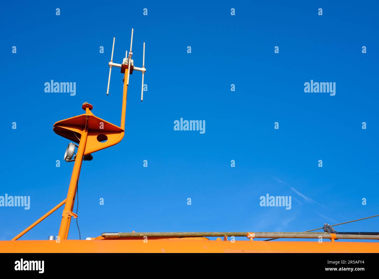 Communication mast on a bright orange Lifeboat or rescue boat against a ...