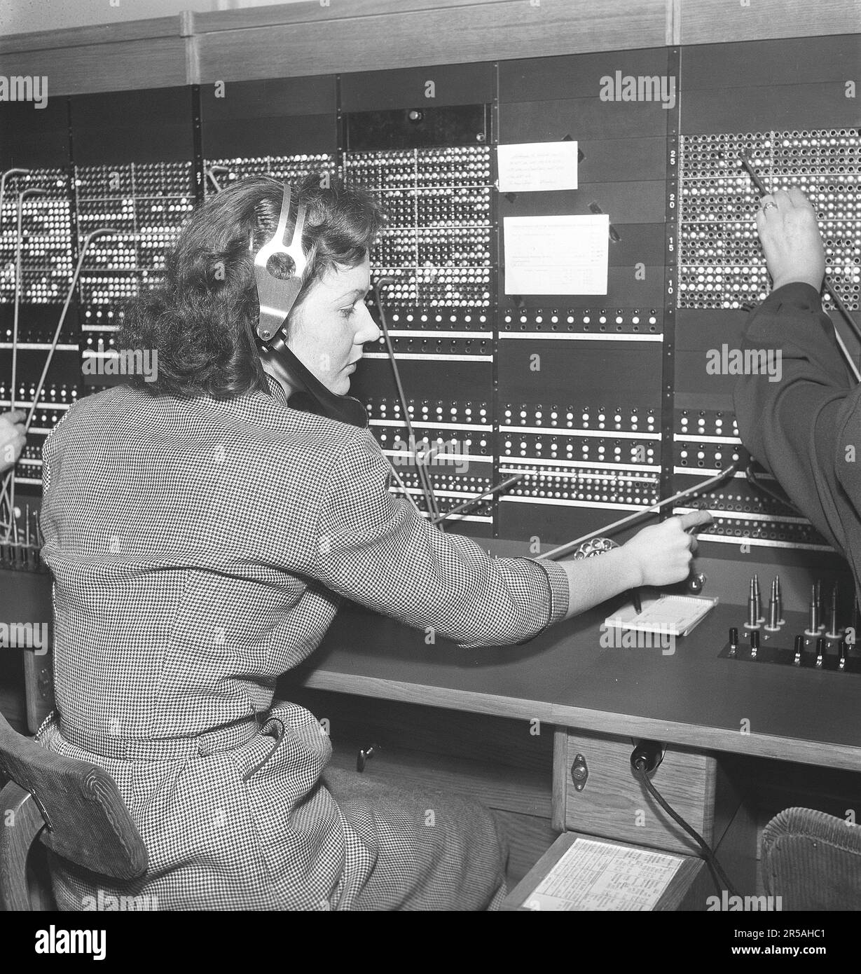 Telephony in the 1950s. Women working at a telephone switchboard as it's operators. A telephone ...
