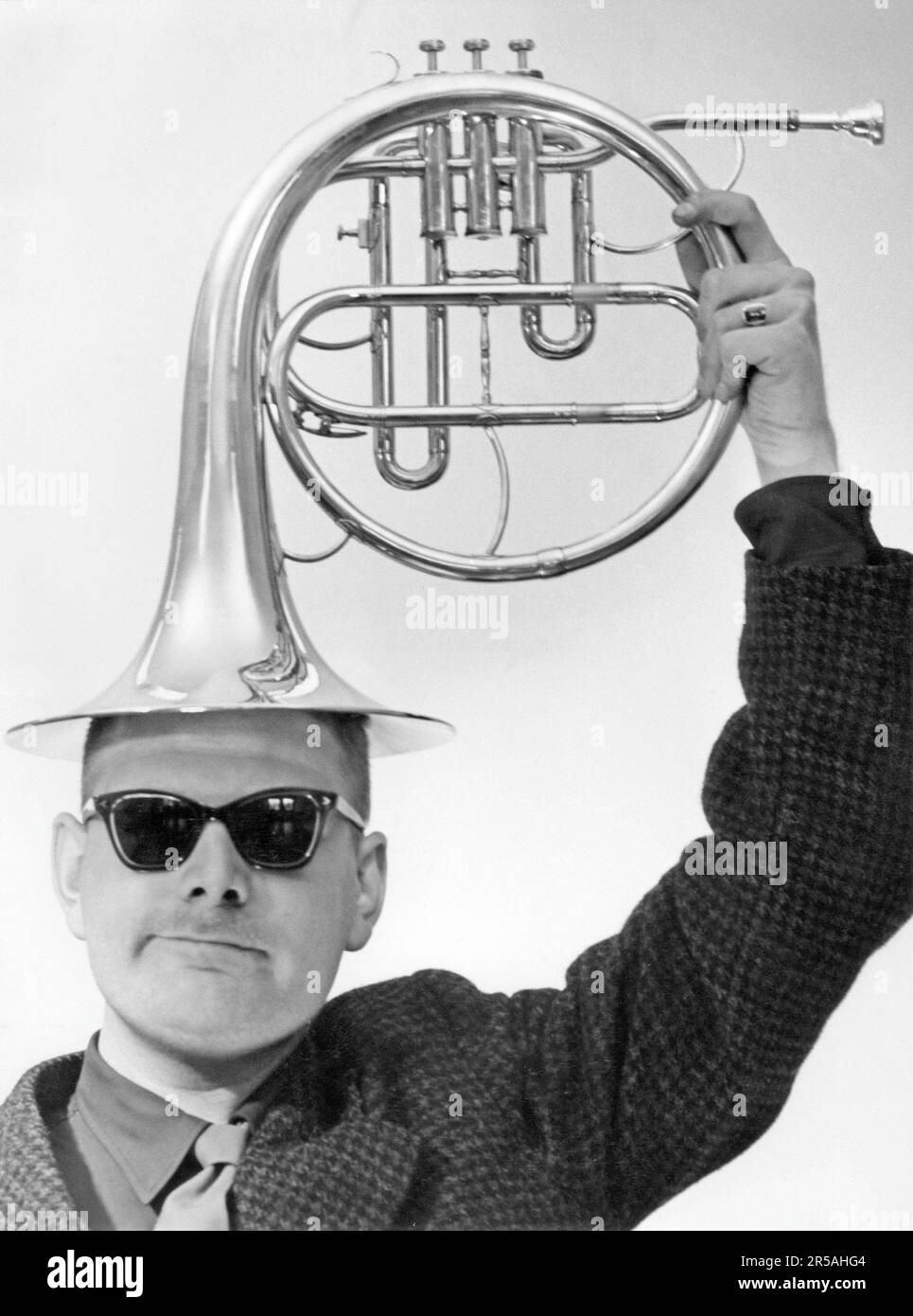 In the 1950s. A man with a brass horn musical instrument on his head ...