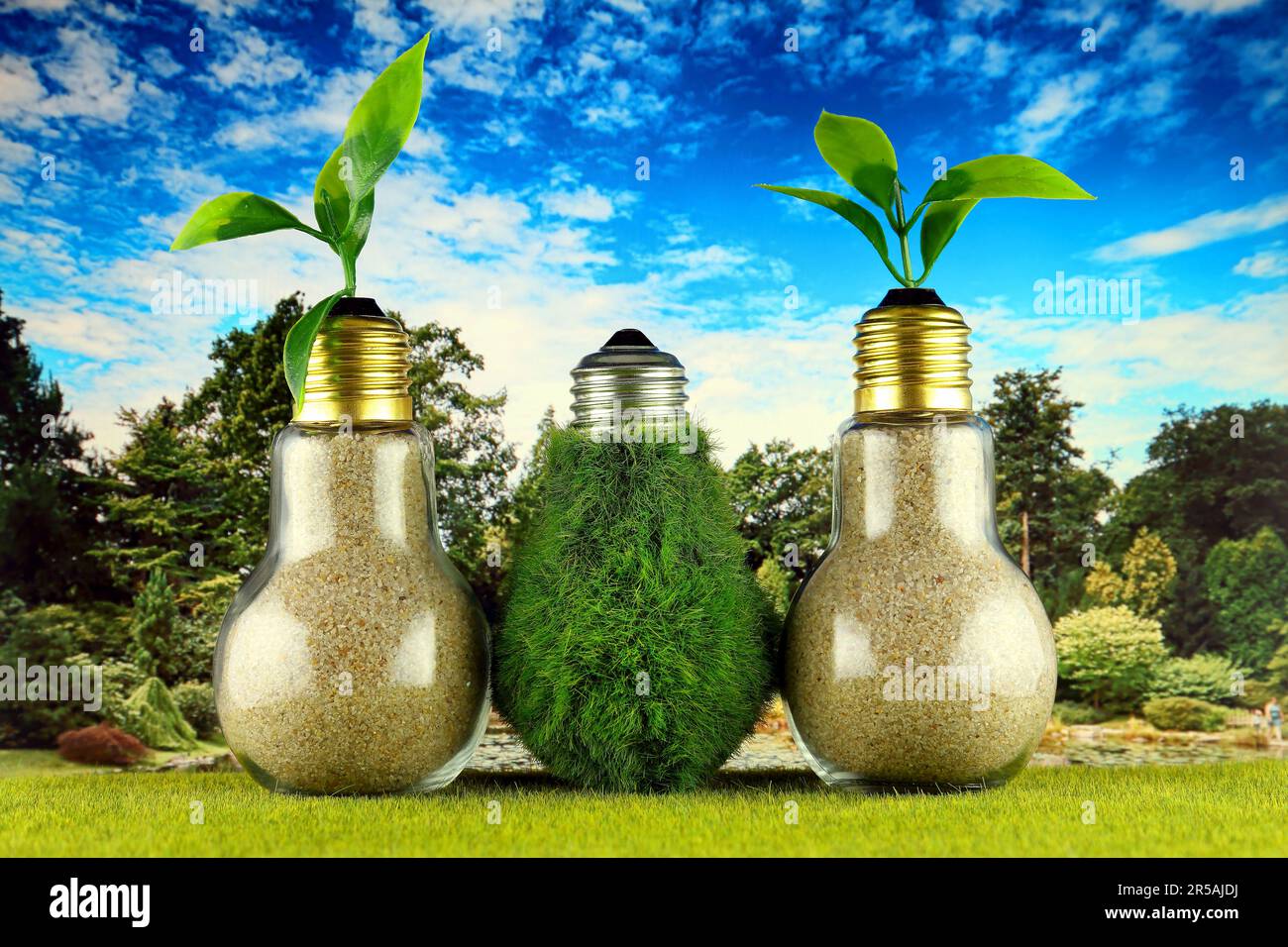 Green eco light bulb on the grass, plants growing inside the light ...