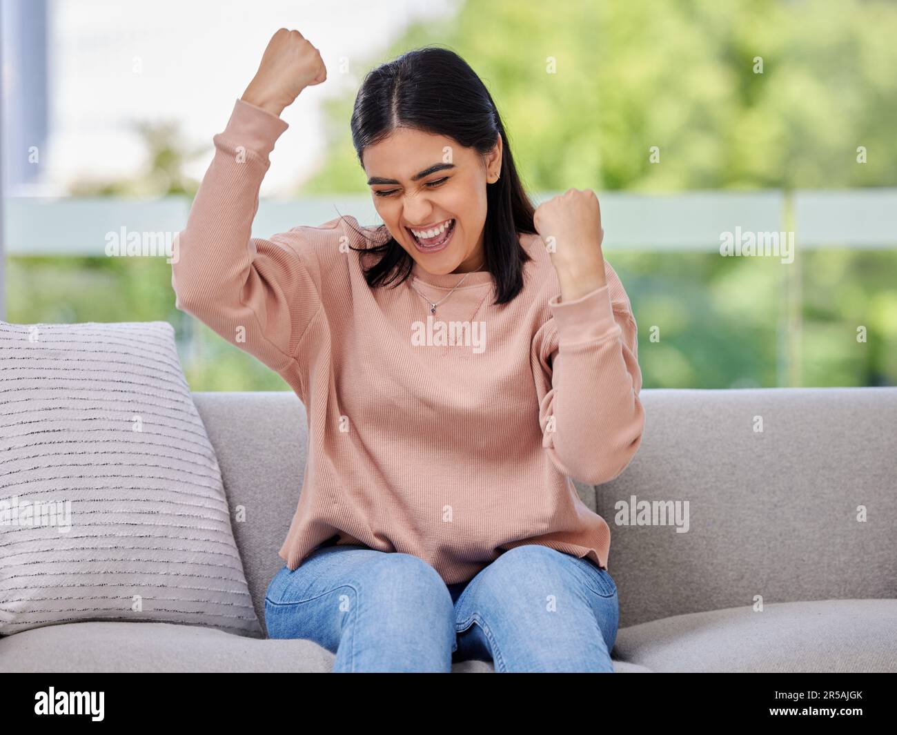 Woman, sofa and fist celebration in home living room, excited and ...