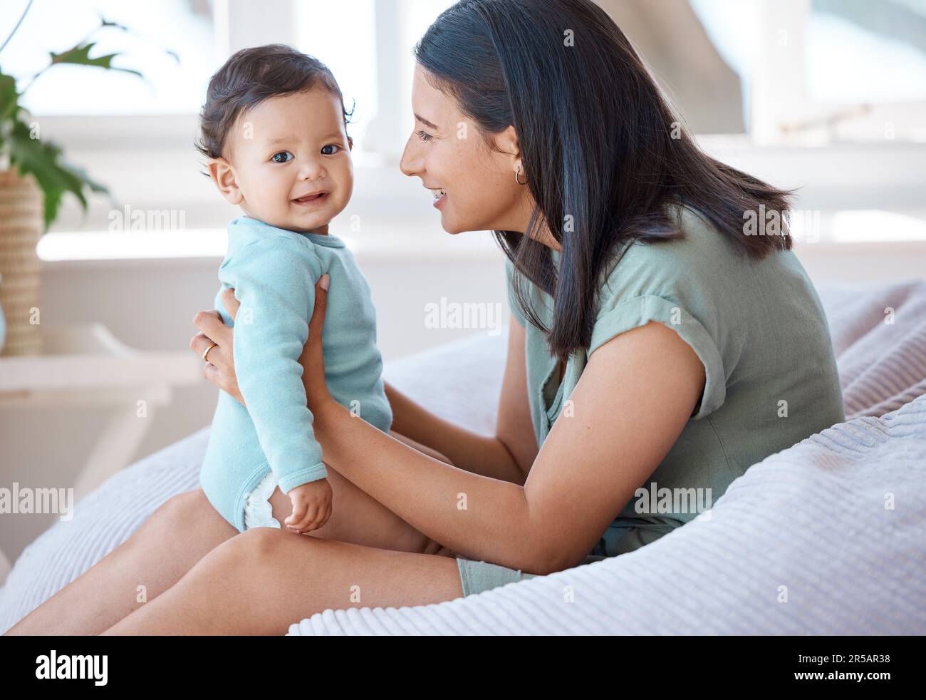Happy, mother and holding with baby on lap in home for love, care and ...