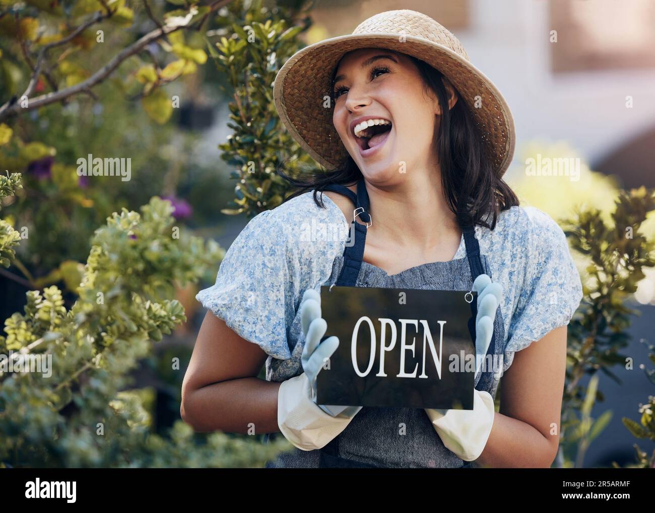 Happy, nursery and open with a woman holding a sign outside of shop for ...