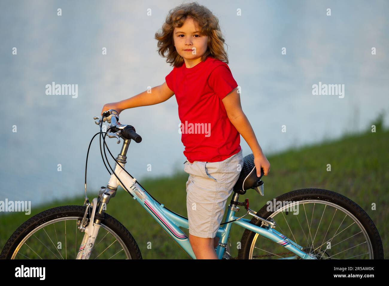 Child riding bicycle. Little kid boy on bicycle along bikeway. Happy ...