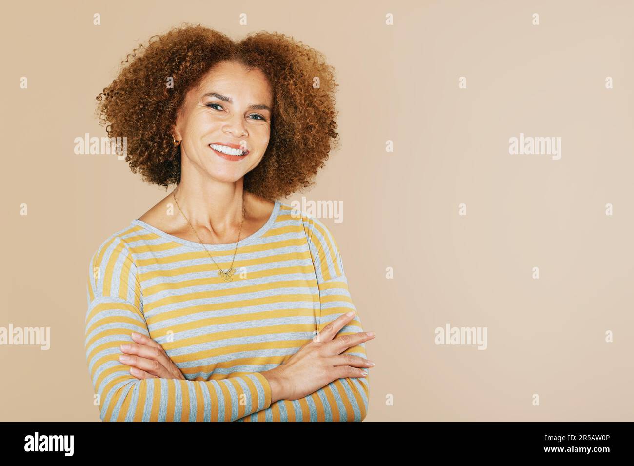 Studio portrait of beautiful middle age woman isolated on beige ...