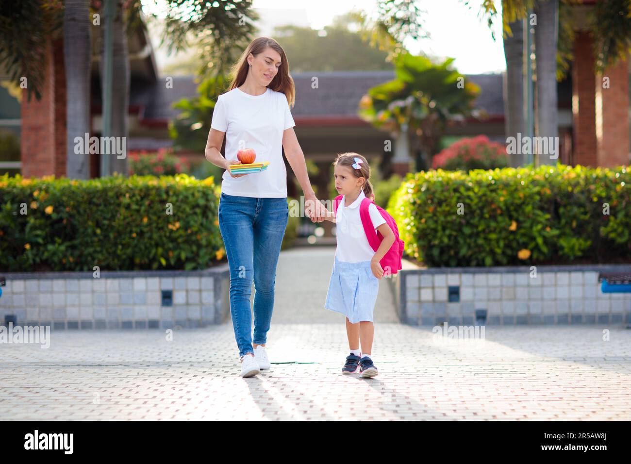 Mother and kids after school. Young mom picking up children after ...