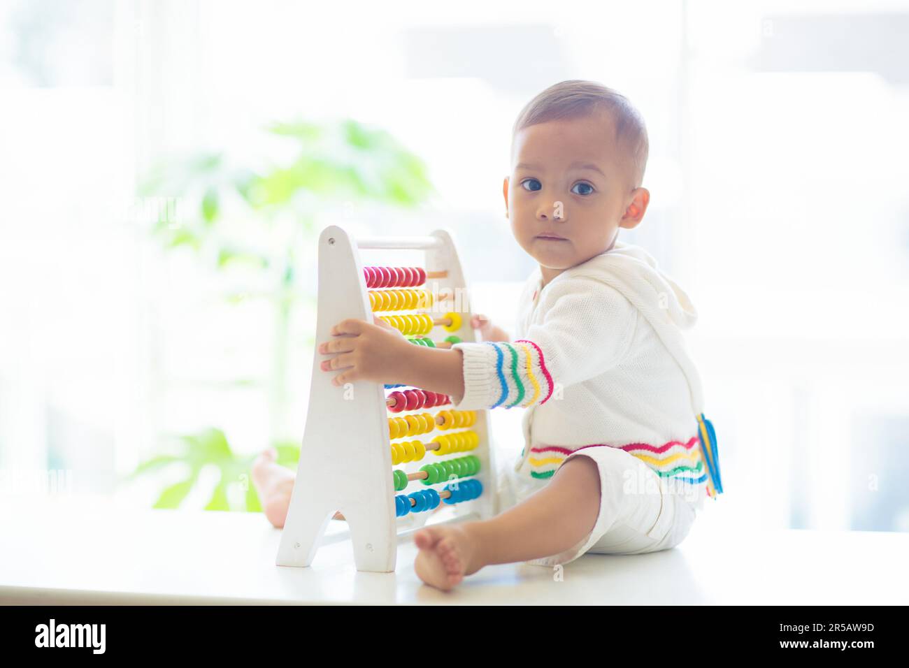 Baby boy playing with wooden abacus. Kids learn to count. Adorable ...