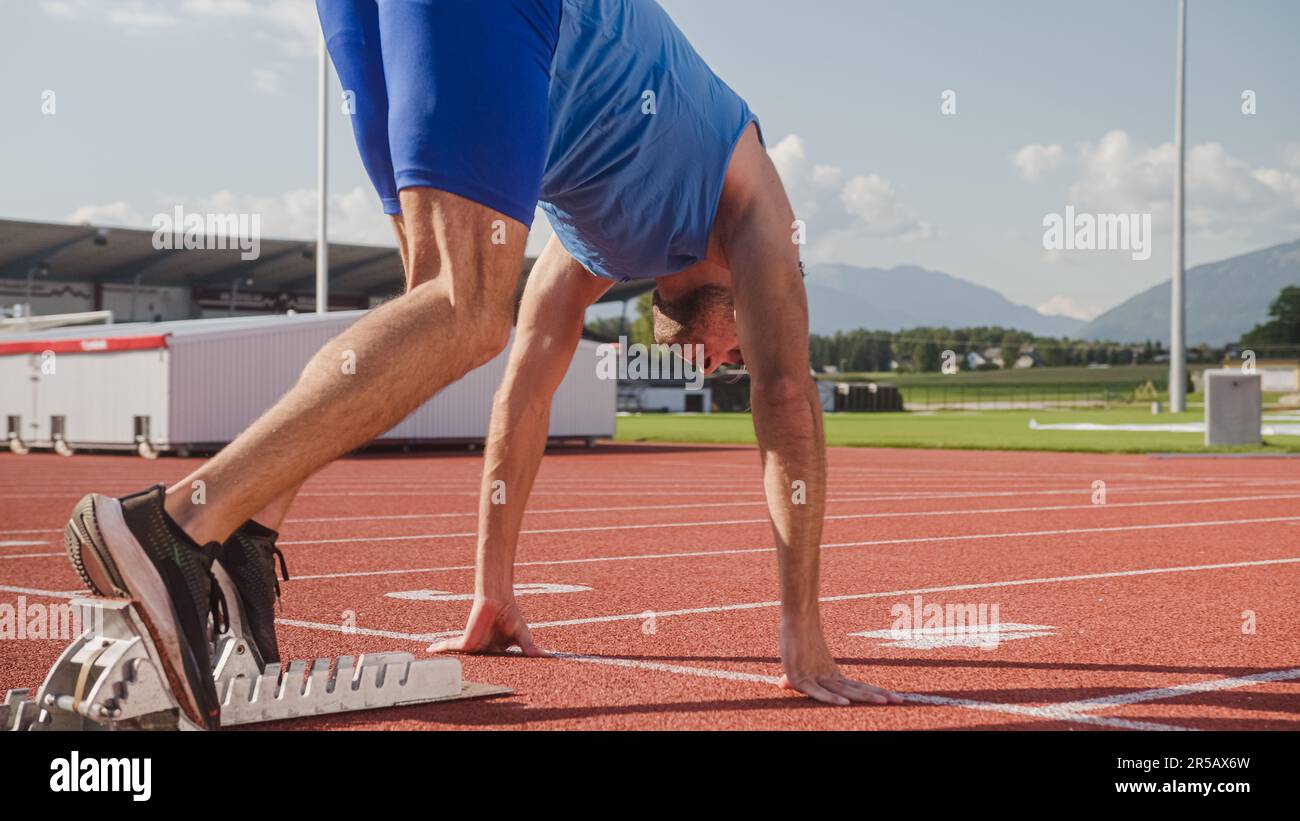Sideways view male professional athlete preparing beyond start line in ...