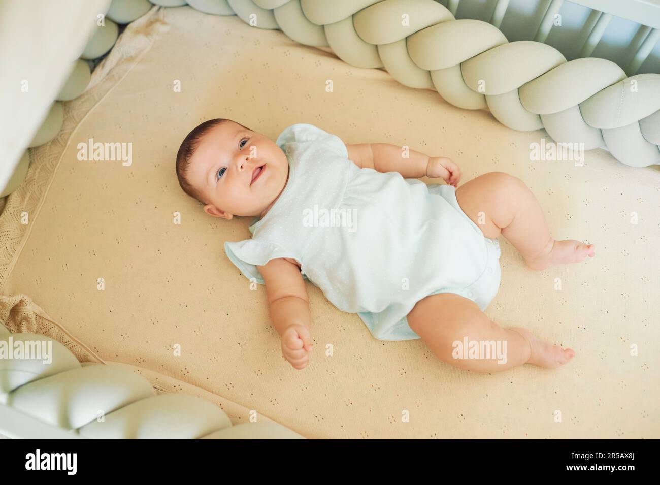 Adorable happy baby lying in crib top view Stock Photo - Alamy