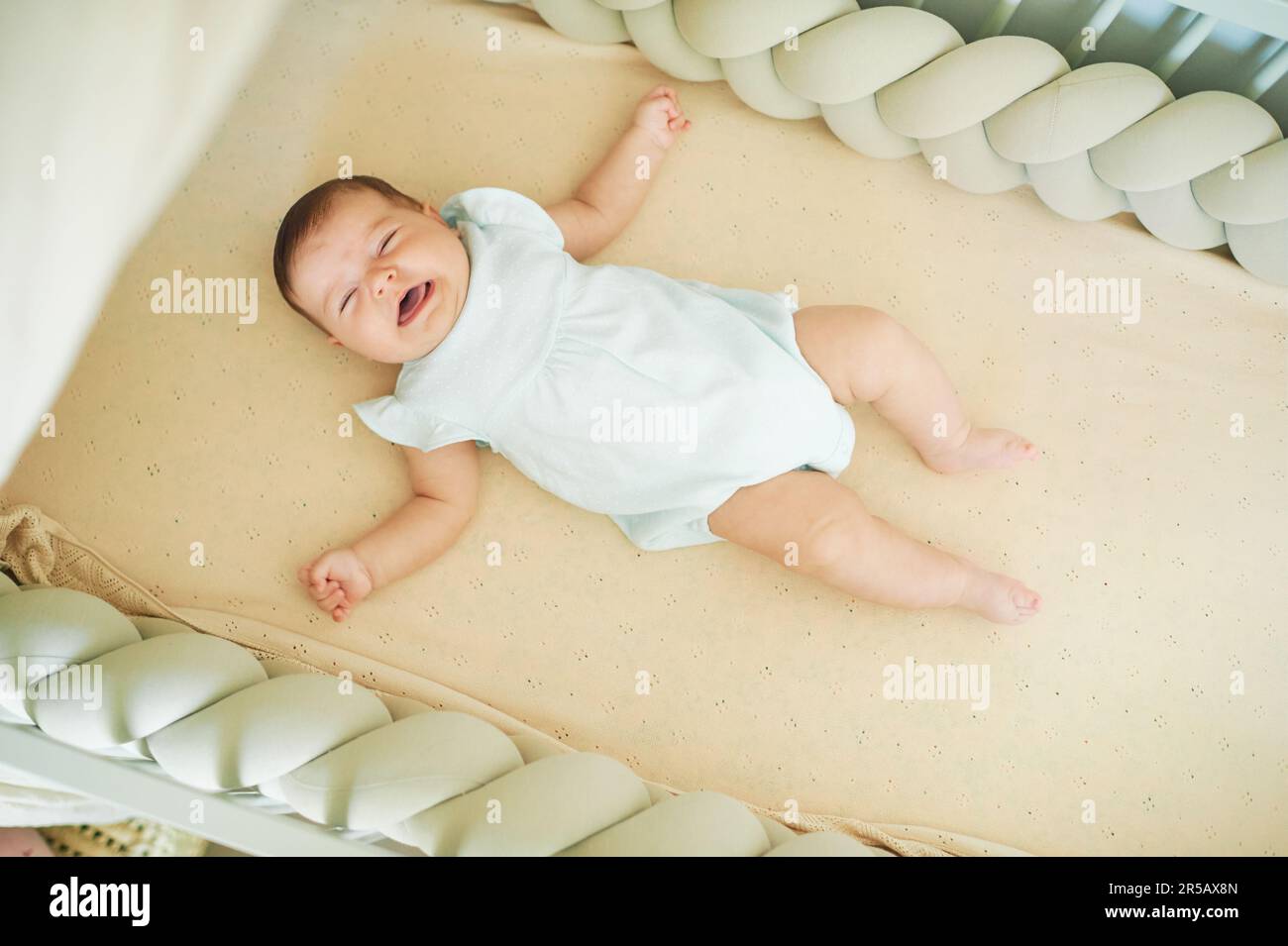Little crying 6 months old baby lying in a crib, top view Stock Photo ...