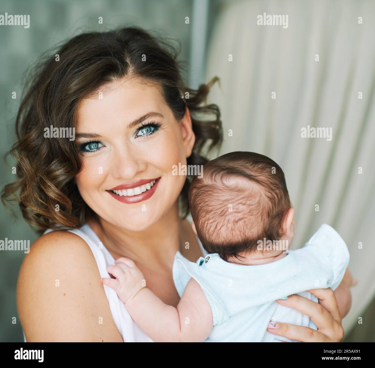 Close up portrait of beautiful young mother holding little baby Stock Photo - Alamy