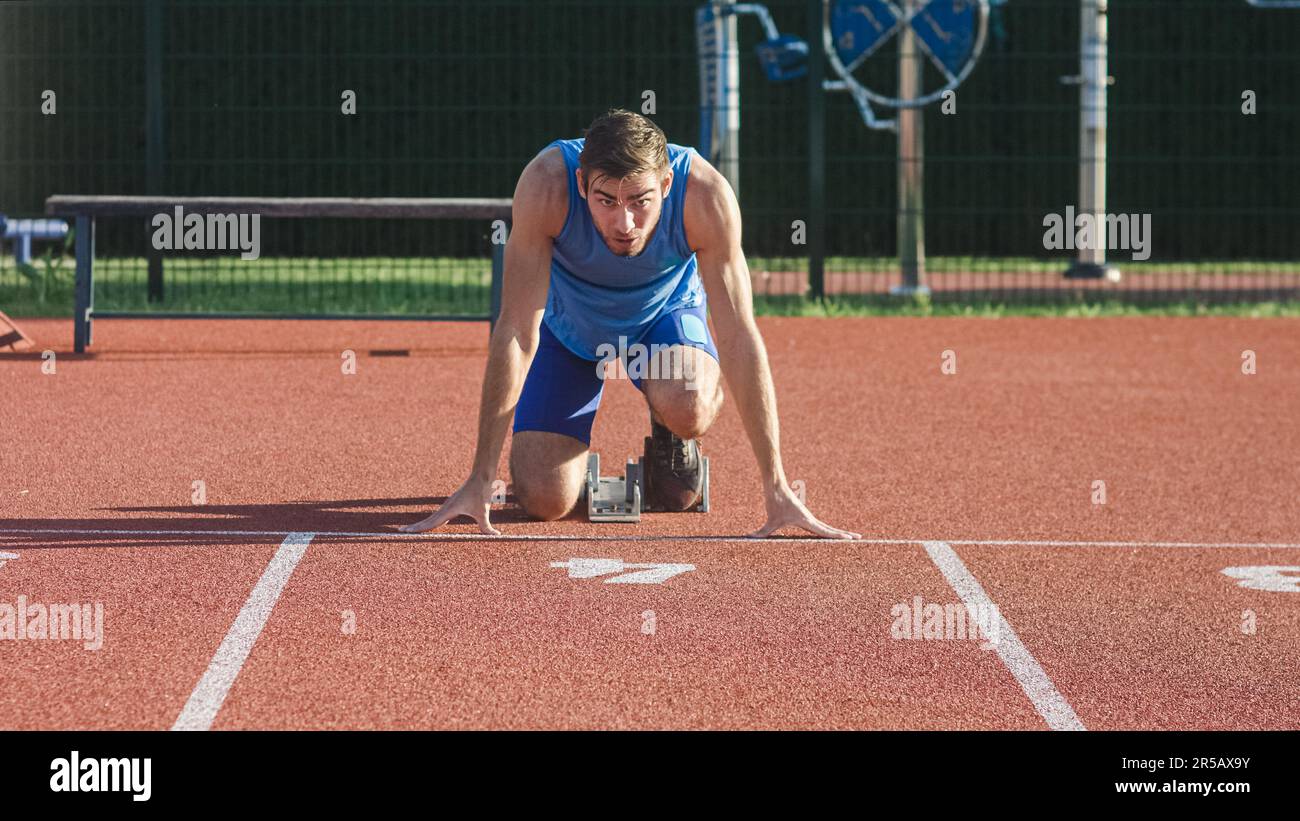 Focused young professional male Caucasian athlete ready for the run ...