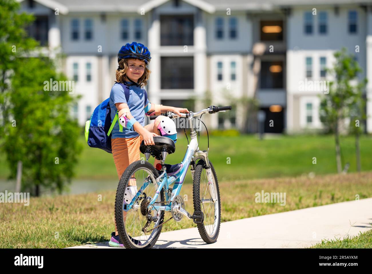 Boy in a helmet riding bike. Boy in safety helmet riding bike in city ...