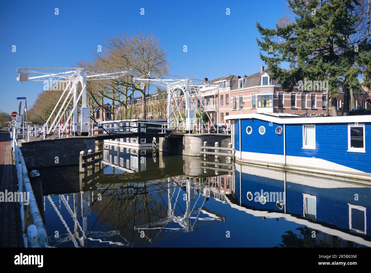 Canal quay covered in bright sunshine and floating home boats on the ...