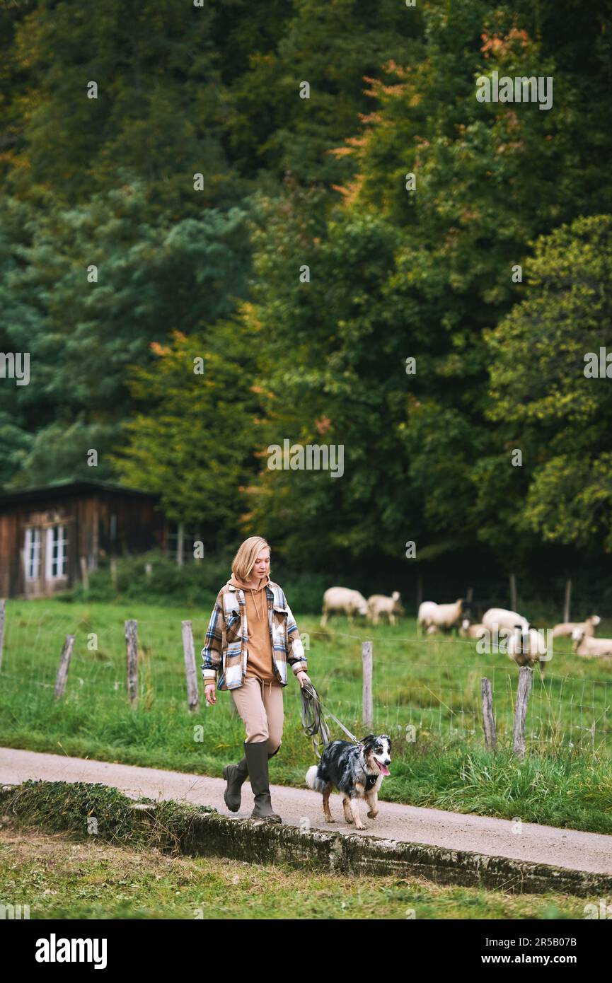 Farm landscape, young woman walking with australian shepherd dog Stock ...