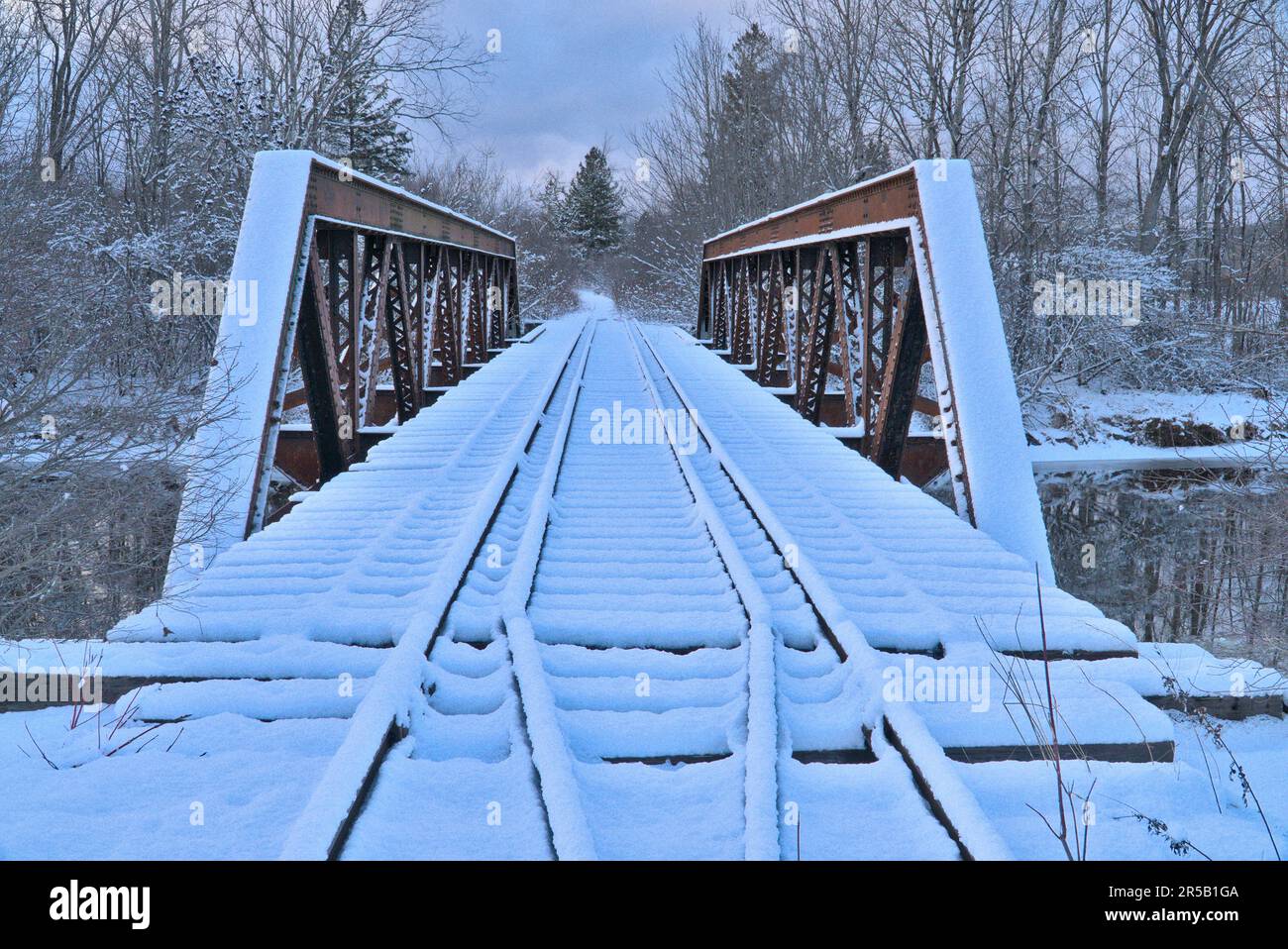 A scenic winter landscape featuring a train track running through snow ...